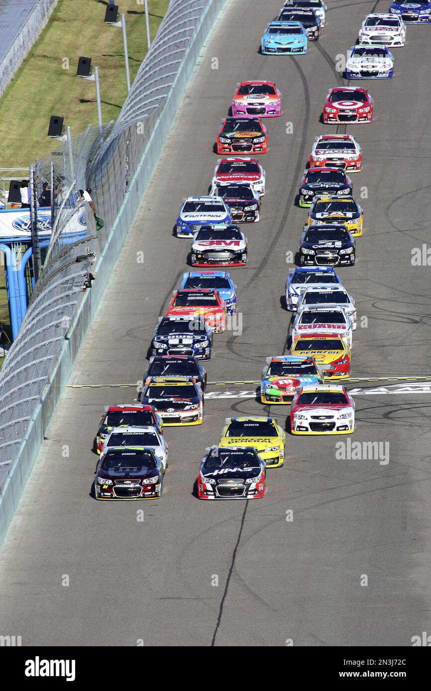 Kurt Busch and Jeff Gordon lead the pack of race cars at the start of ...