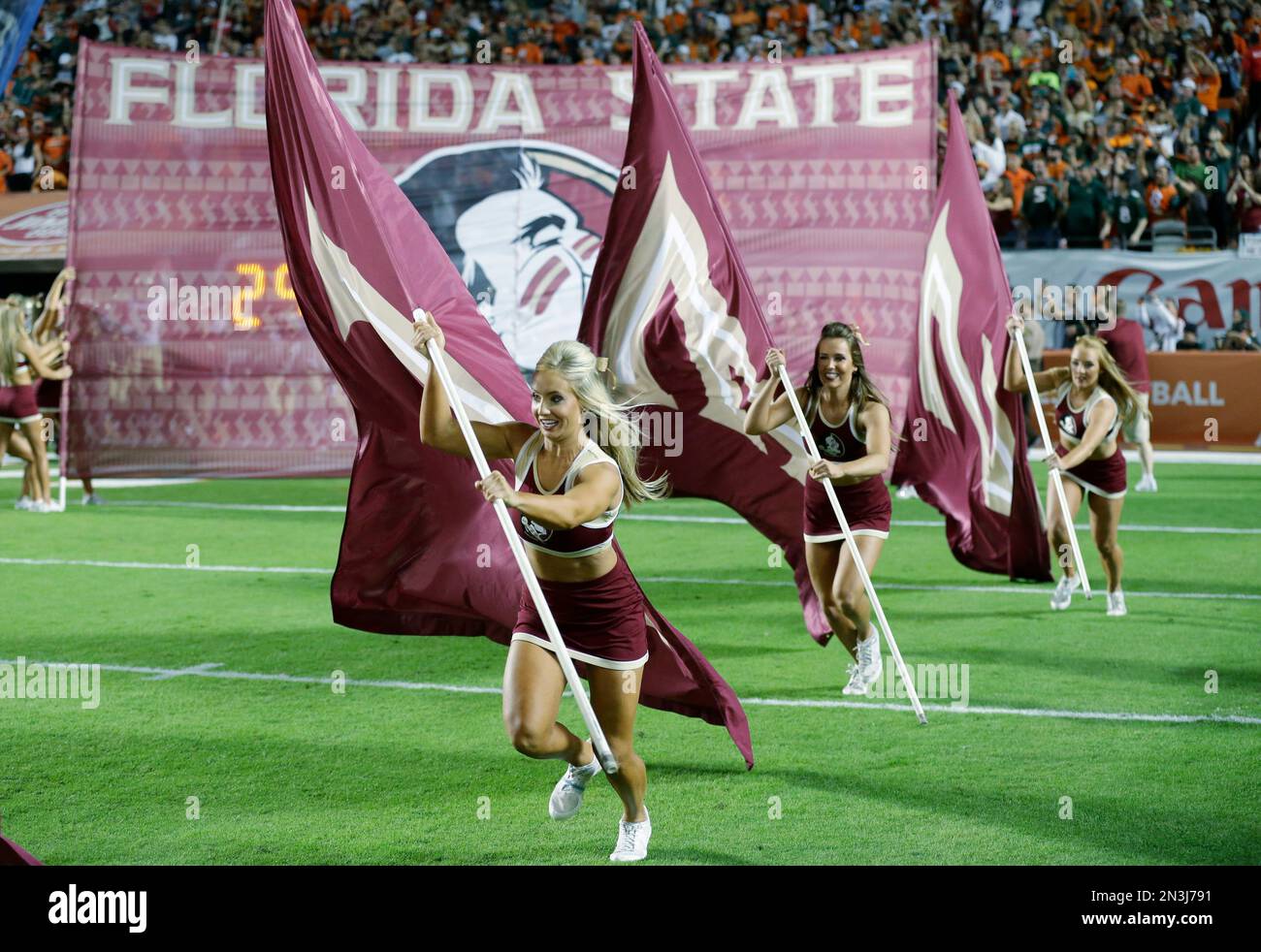 Florida State cheerleaders run with flags as the team comes out before ...