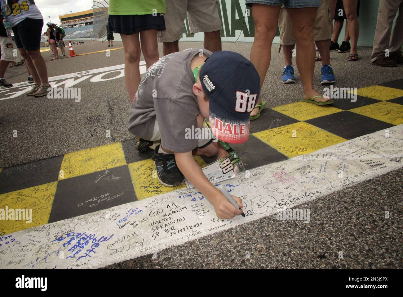 A young race fan signs the finish line at the NASCAR Sprint Cup ...