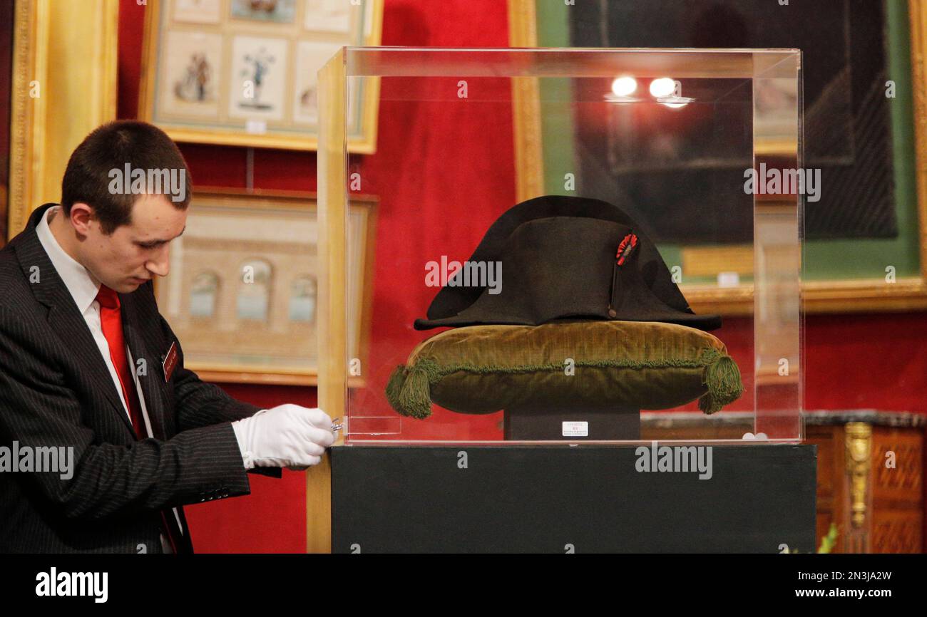 An employee prepares Napoleon's hat before its auction in Fontainebleau ...
