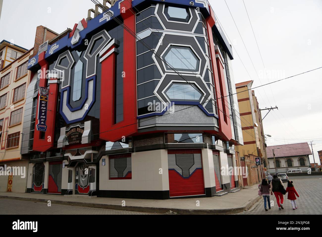 People walk next to a mini mansion decorated in the Transformers ...