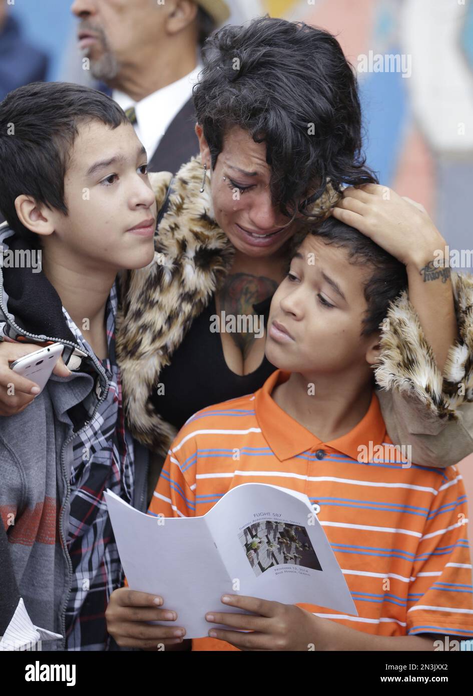 Yasmin Hernandez, center, cries while holding her children Nicholas ...