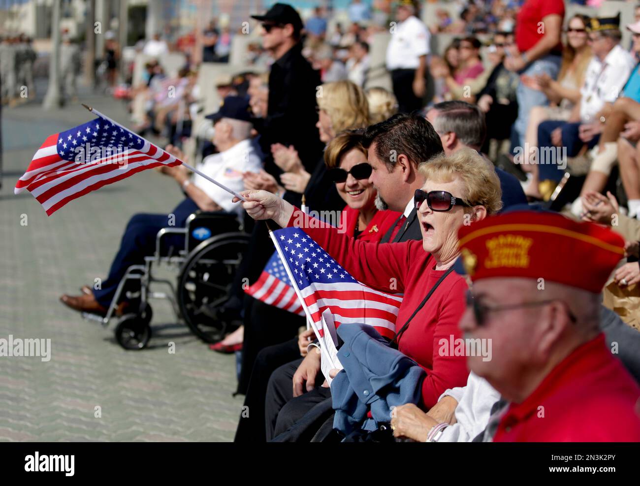 Onlookers wave flags and sing along during the playing of the "Marines ...
