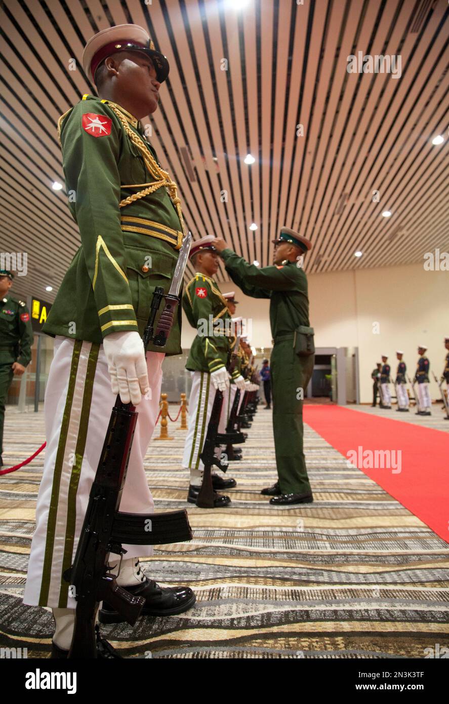 Myanmar soldiers in ceremonial uniforms stands while an army officer ...