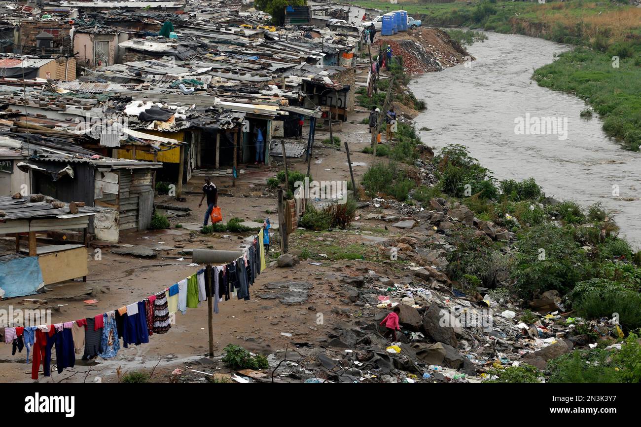 CORRECTS DAY IN DATE A man walks in along an informal settlement as a ...