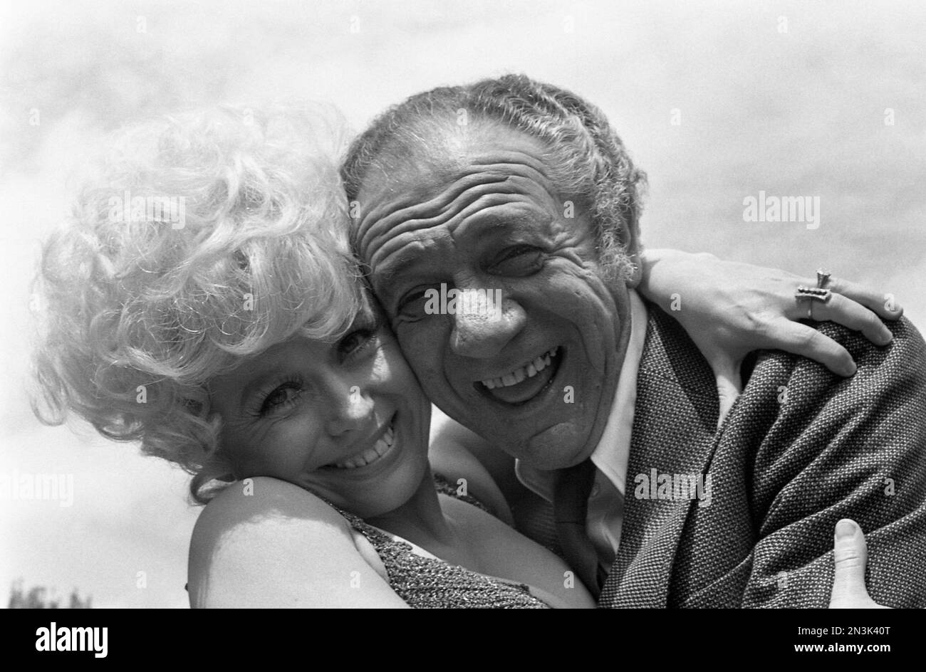 British comedy actor Sid James gets a friendly farewell cuddle from his ...