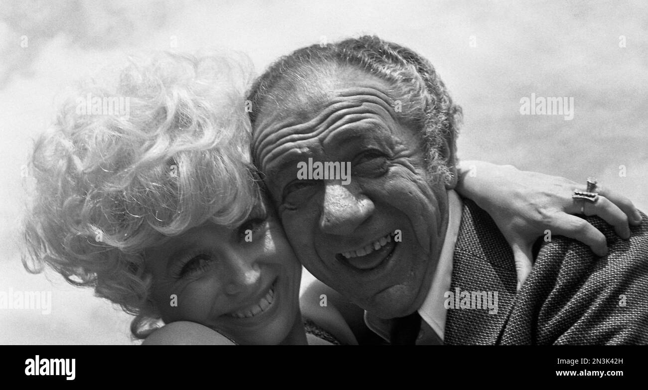 British comedy actor Sid James gets a friendly farewell cuddle from his ...