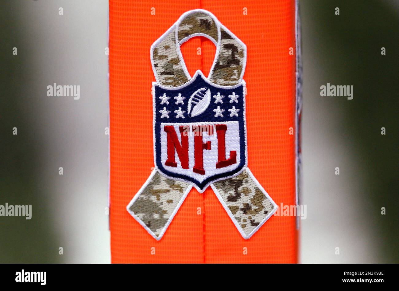 A camouflaged NFL ribbon logo is shown on a goal line marker to honor ...