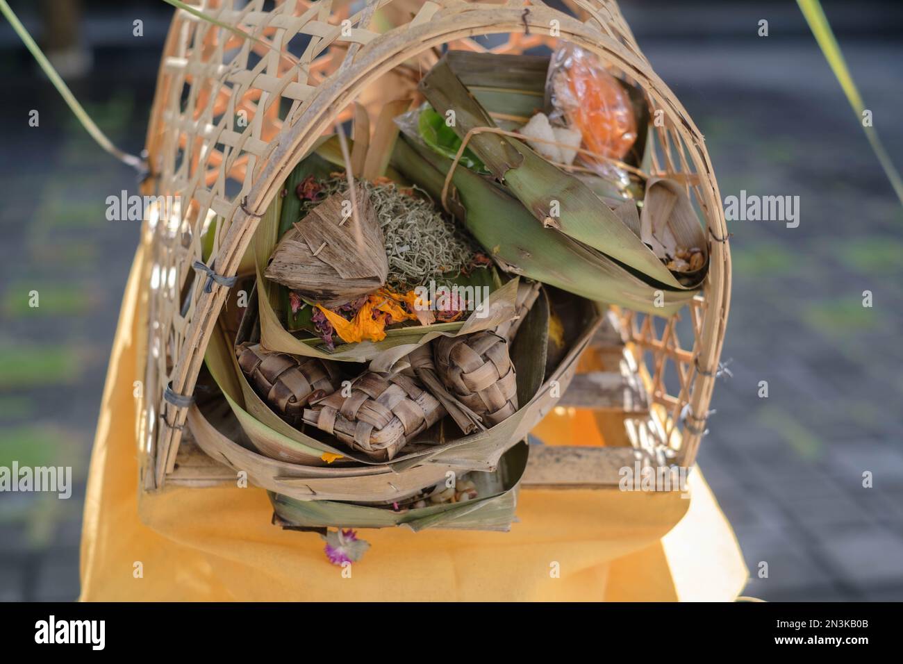 Sacred Canang sari offerings arranged on traditional bamboo-weaved ...