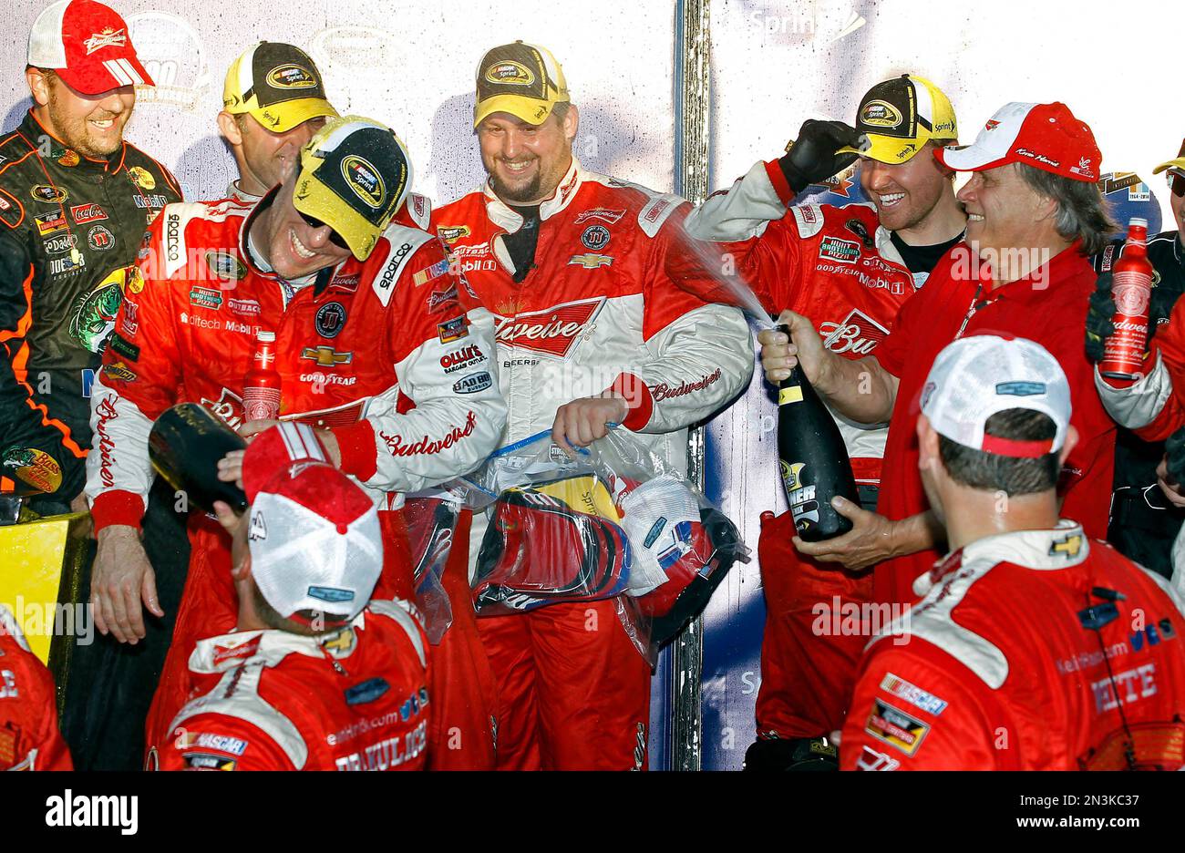 Driver Kevin Harvick, left, is showered with champagne by car owner ...