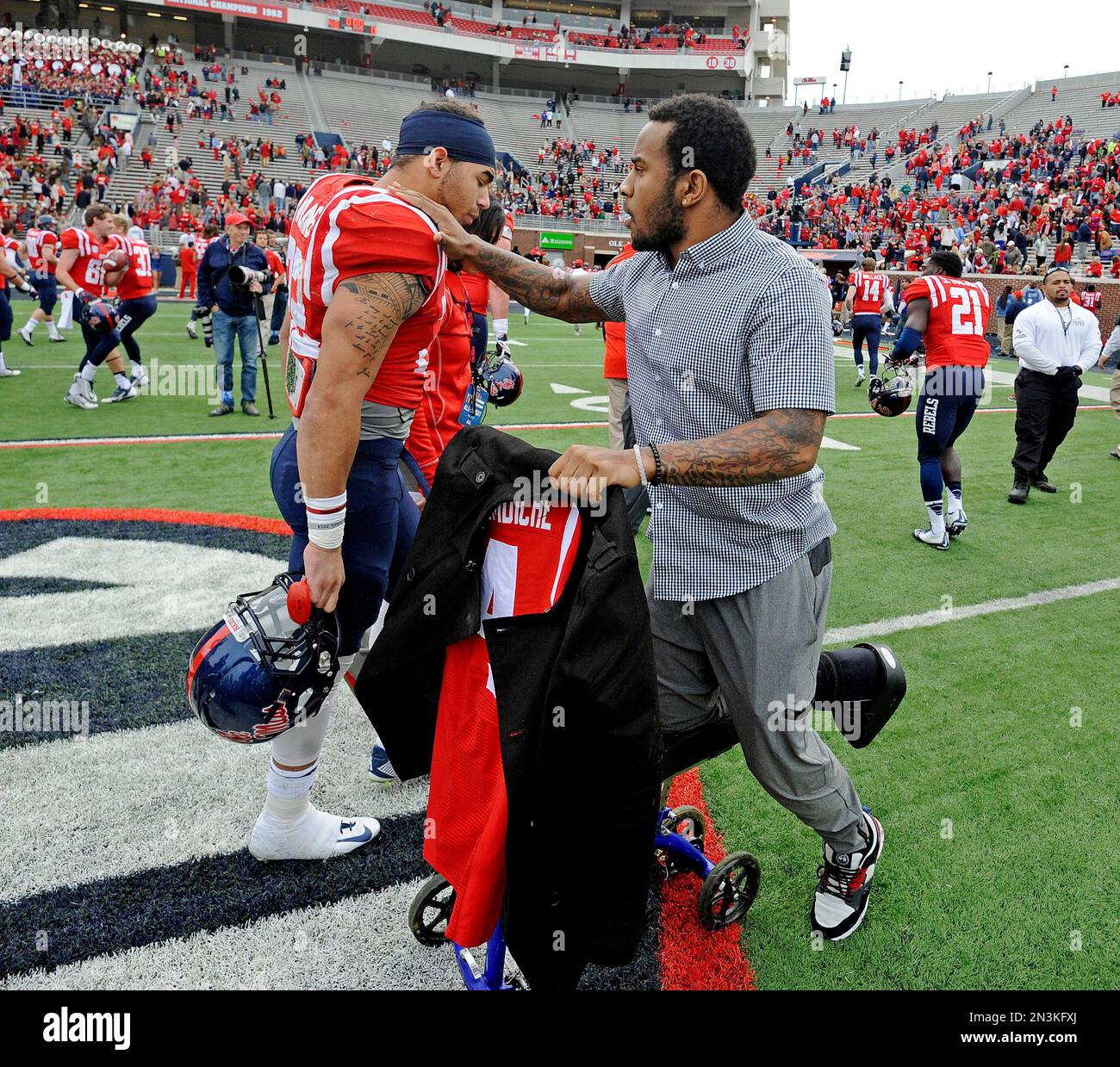 Mississippi's Jordan Wilkins, left, talks to injured linebacker Denzel ...