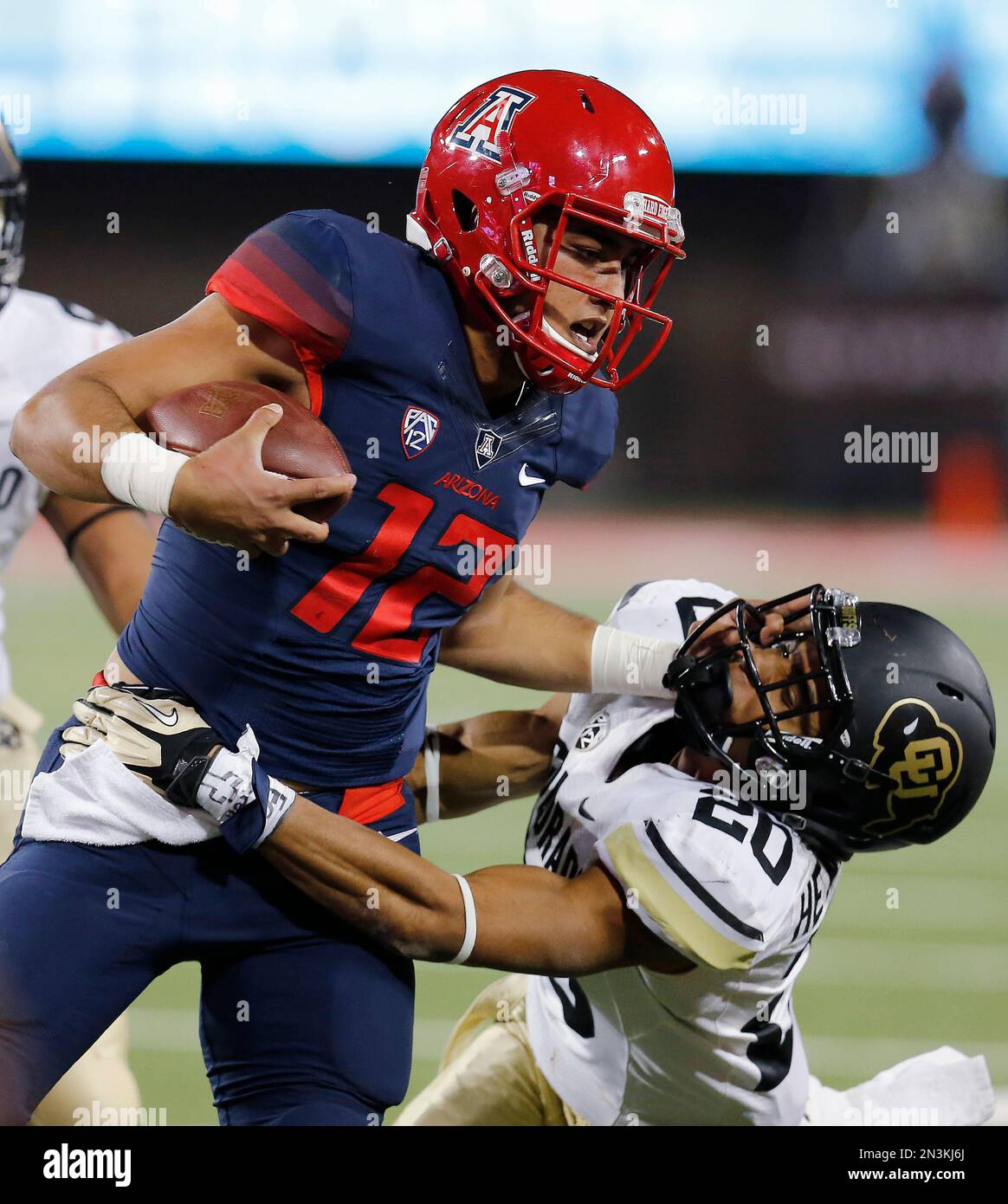 Arizona quarterback Anu Solomon (12) stiff-arms Colorado cornerback ...