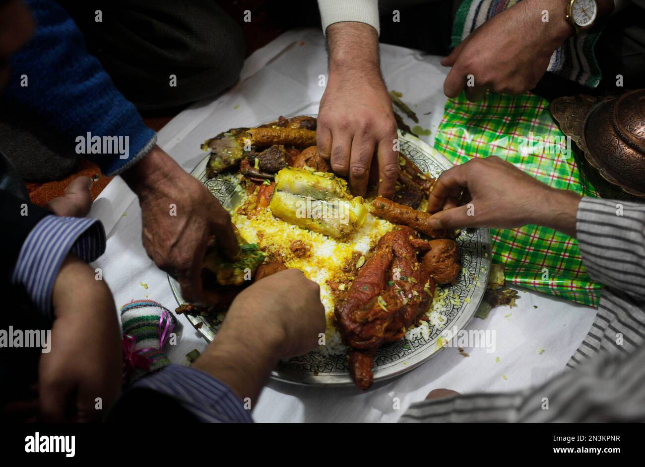 In this Friday, Nov. 7, 2014 photo, Kashmiri men eat a wedding feast ...