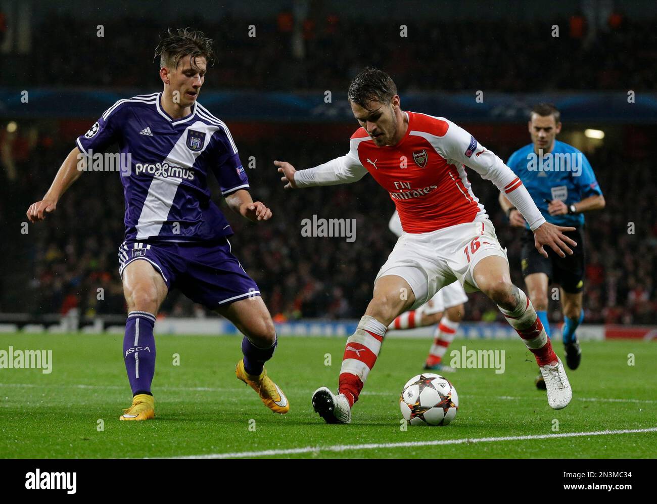 Arsenal's Aaron Ramsey, right, and Anderlecht's Dennis Praet challenge ...