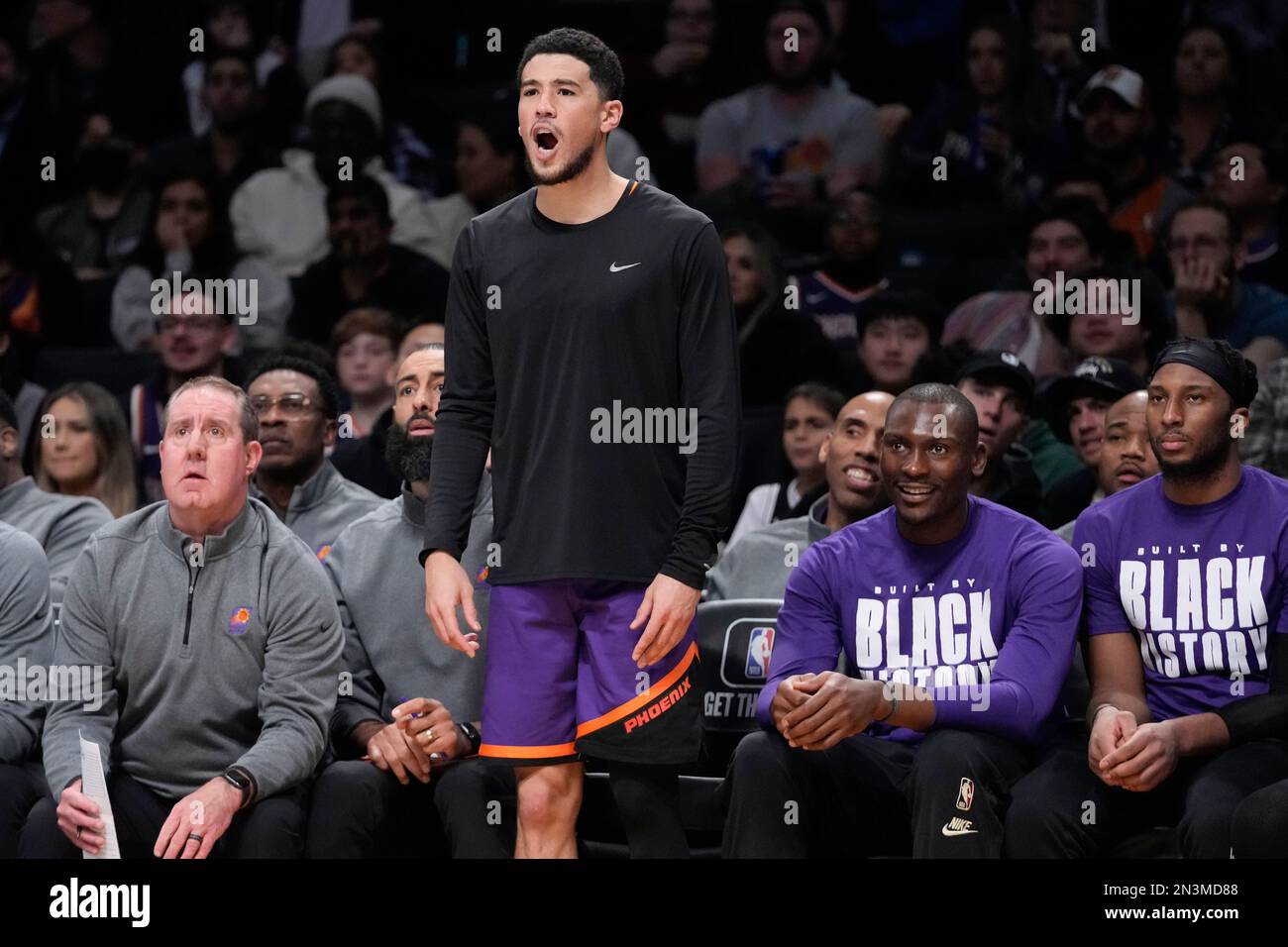 Phoenix Suns guard Devin Booker, center, reacts from the bench during ...