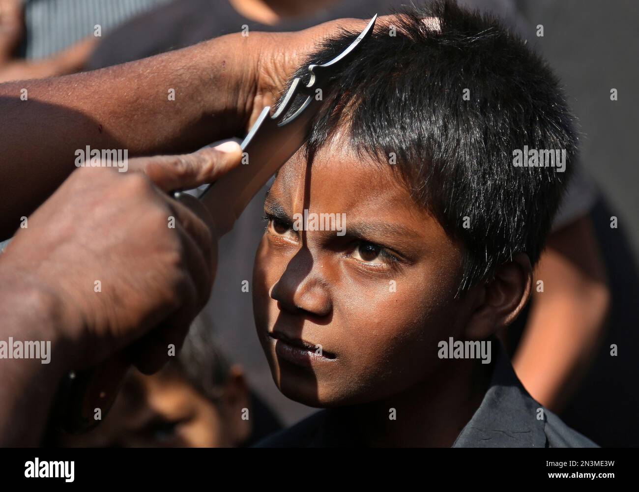 An Indian Shiite Muslim prepares to put a cut on the forehead of a ...