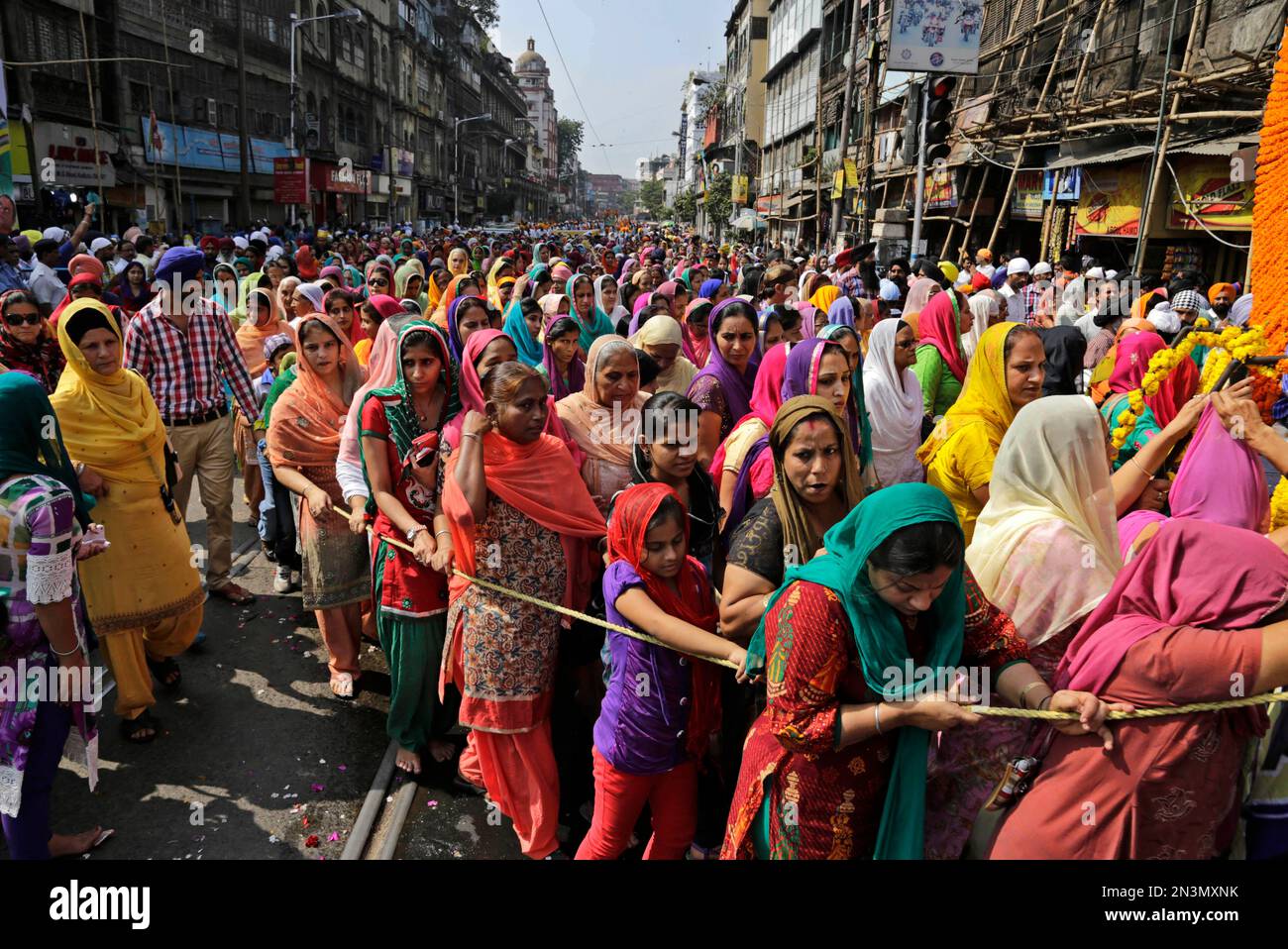 Sikh women line up behind a rope held by volunteers to control crowd as ...
