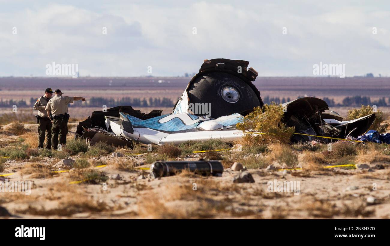 Law enforcement officers take a closer look at the wreckage near the ...