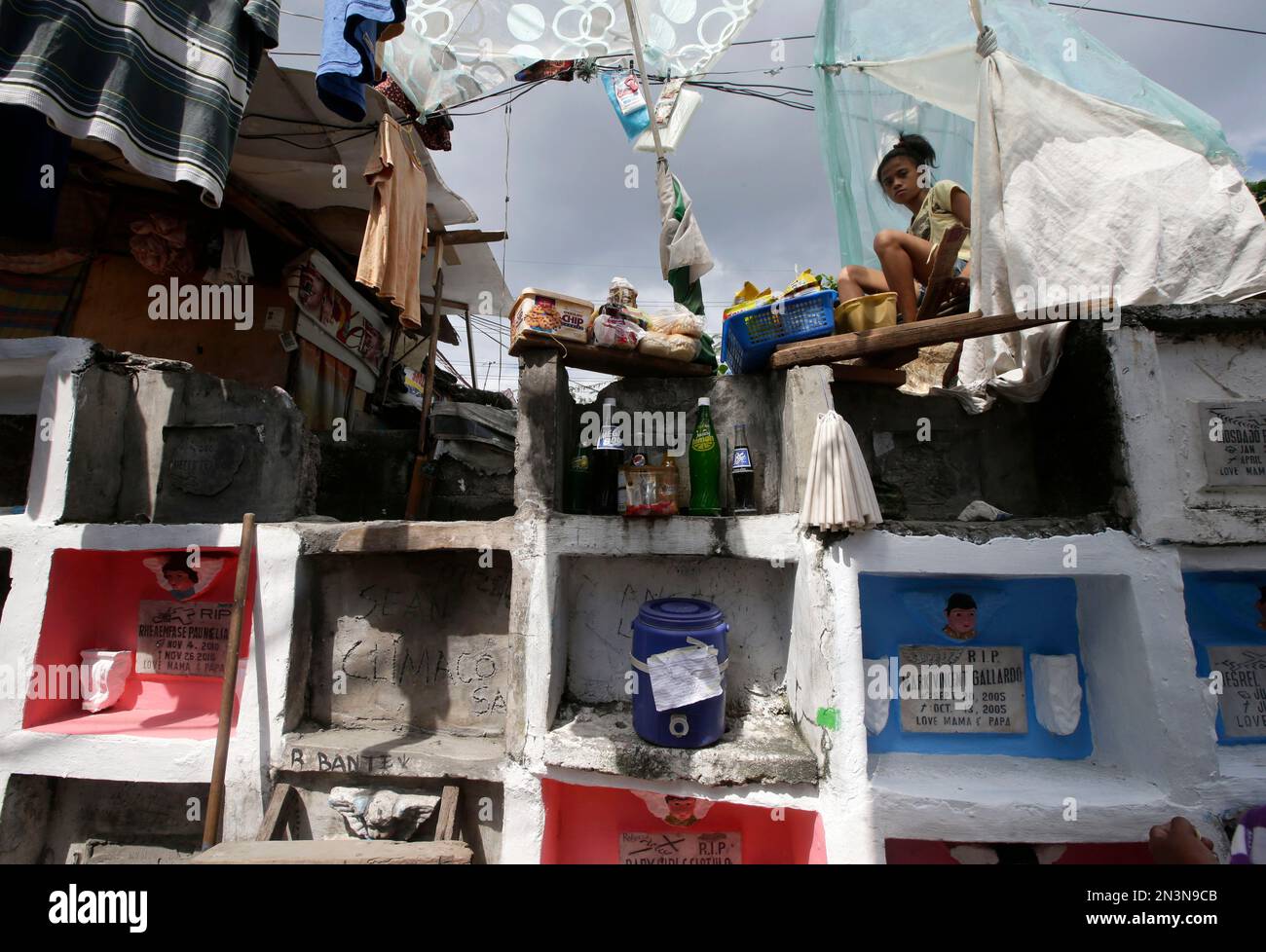 An informal settler mans her improvised store on top of multi-level ...