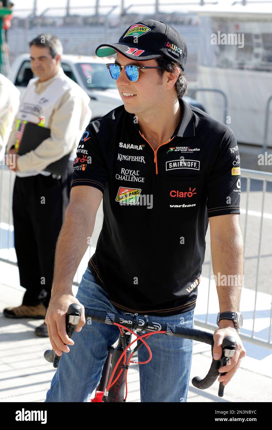 Force India driver Sergio Perez, of Mexico, prepares to ride a bike on ...