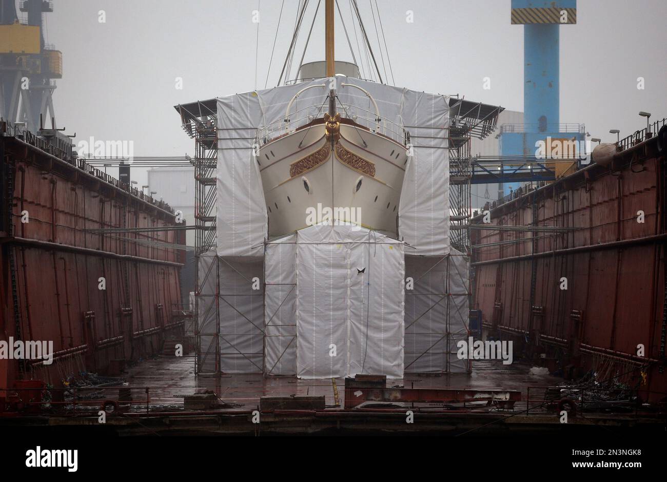 The yacht Nahlin undergoes maintenance inside a dry dock at the harbor ...