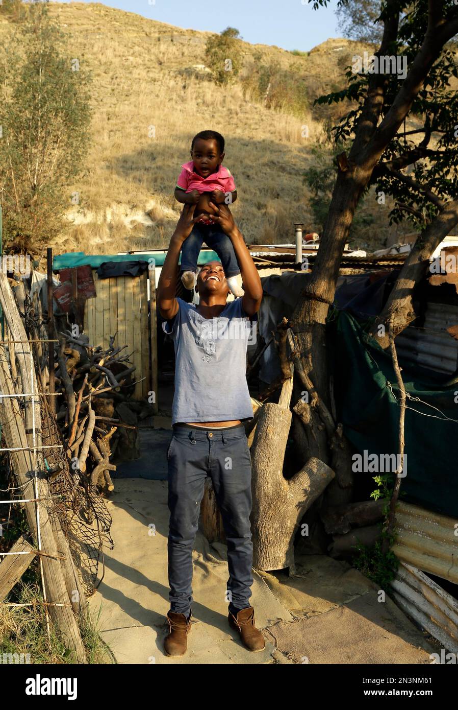 Thabiso Matlala, plays with his sister's daughter named Mpho Matlala, whilst standing outside ...
