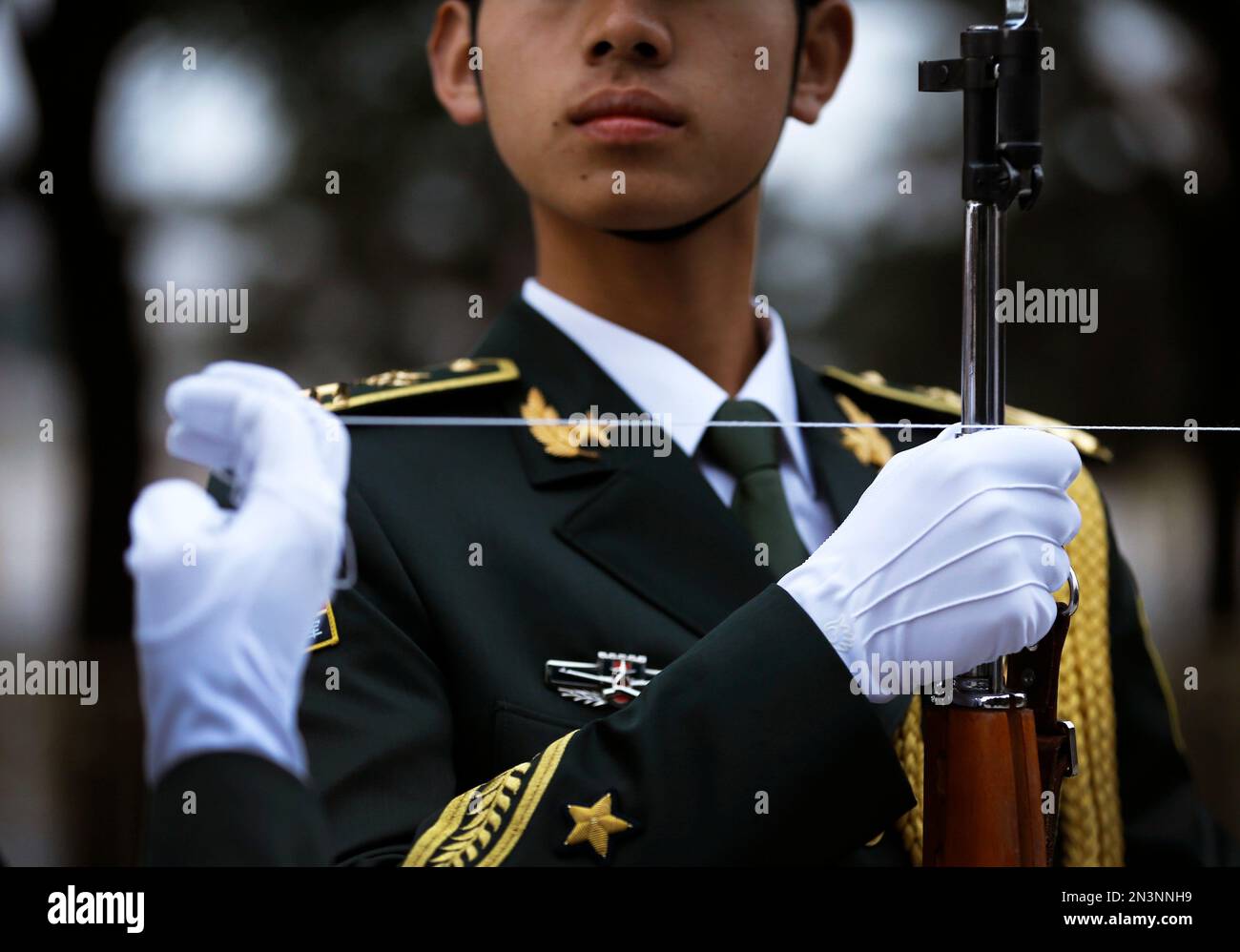 A Chinese People's Liberation Army soldier uses a string to line up a ...