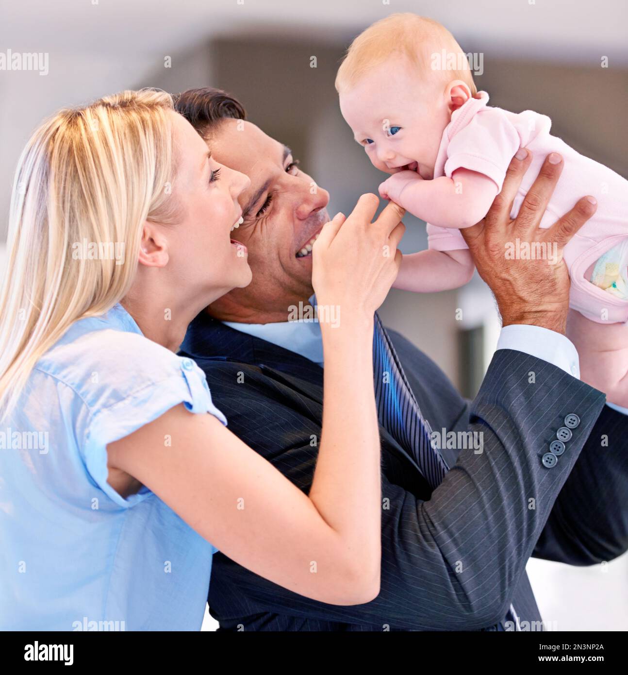 Playful daddy, loving mommy. Young mother laughing as her husband lifts ...