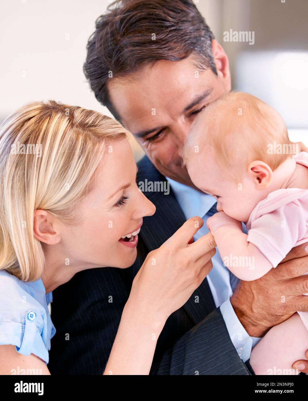 They both love her endlessly. Young couple doting over their cute baby ...