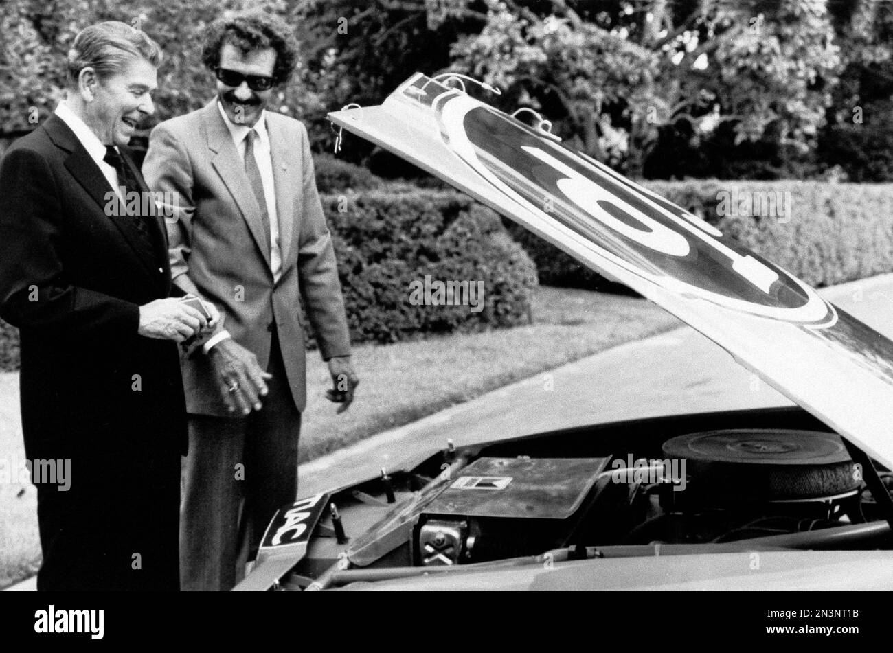President Ronald Reagan and race car driver Richard Petty check under ...