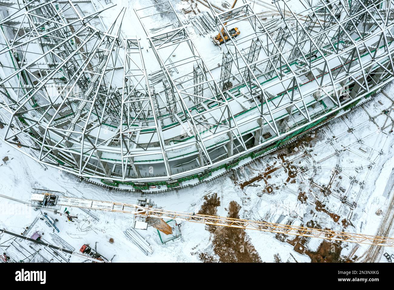 aerial top view of snowy building site with yellow crane. new stadium ...