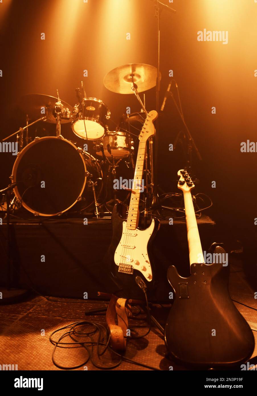 Tools of the rock trade. A drunkit and electric guitars standing on a ...