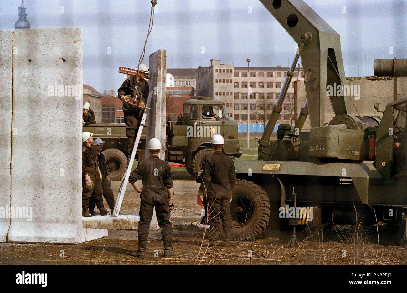 East German border guards build a new section of the Berlin Wall ...