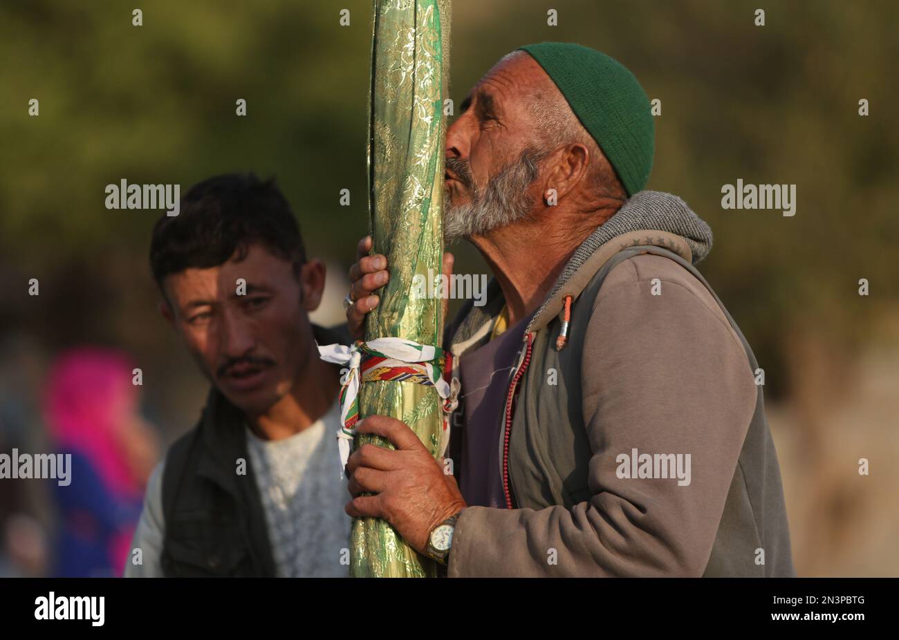 An Afghan Shiite man kisses the holy mace for blessings ahead of Islam ...