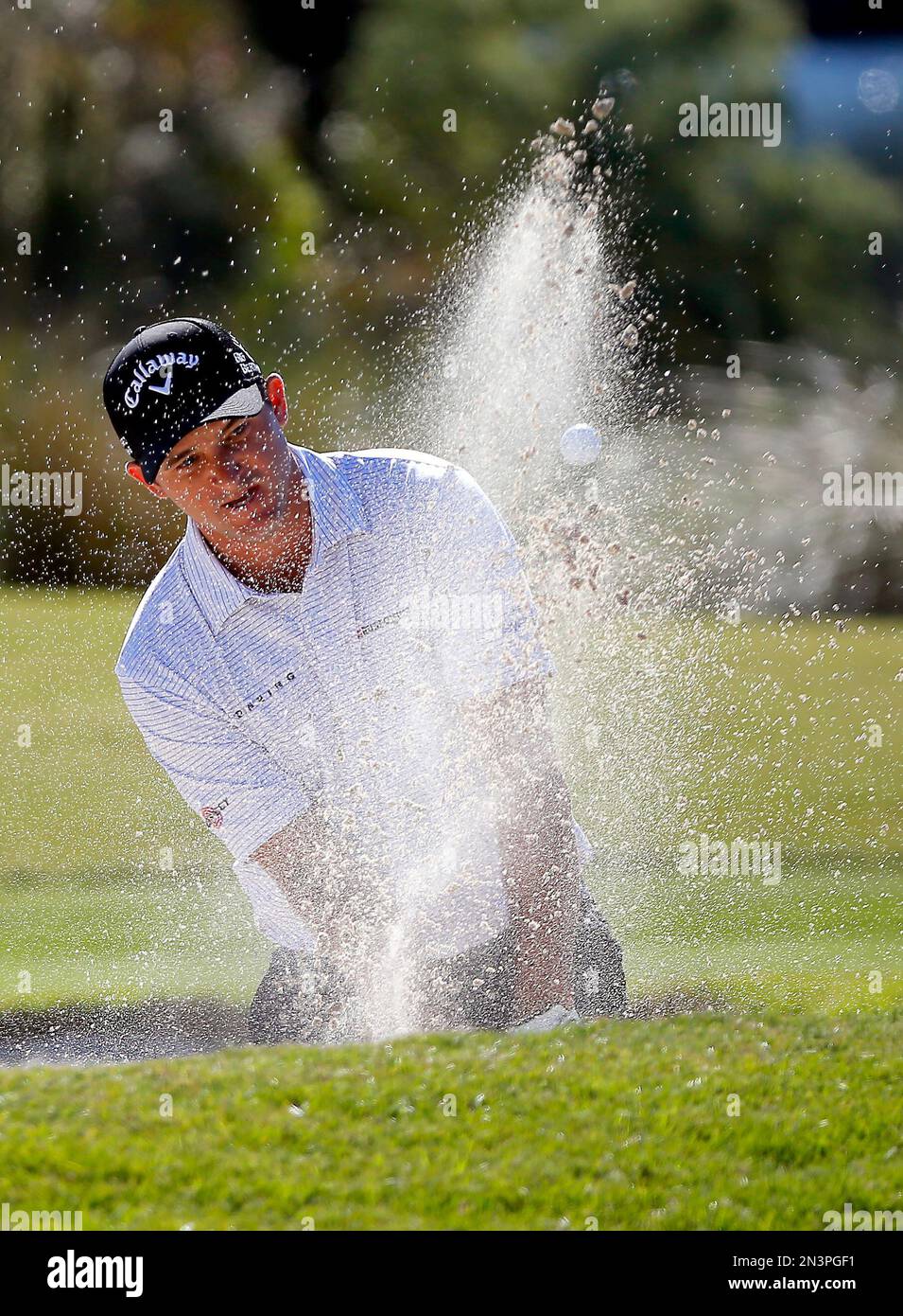 Sam Saunders hits out of the bunker on the 17th green during the first ...