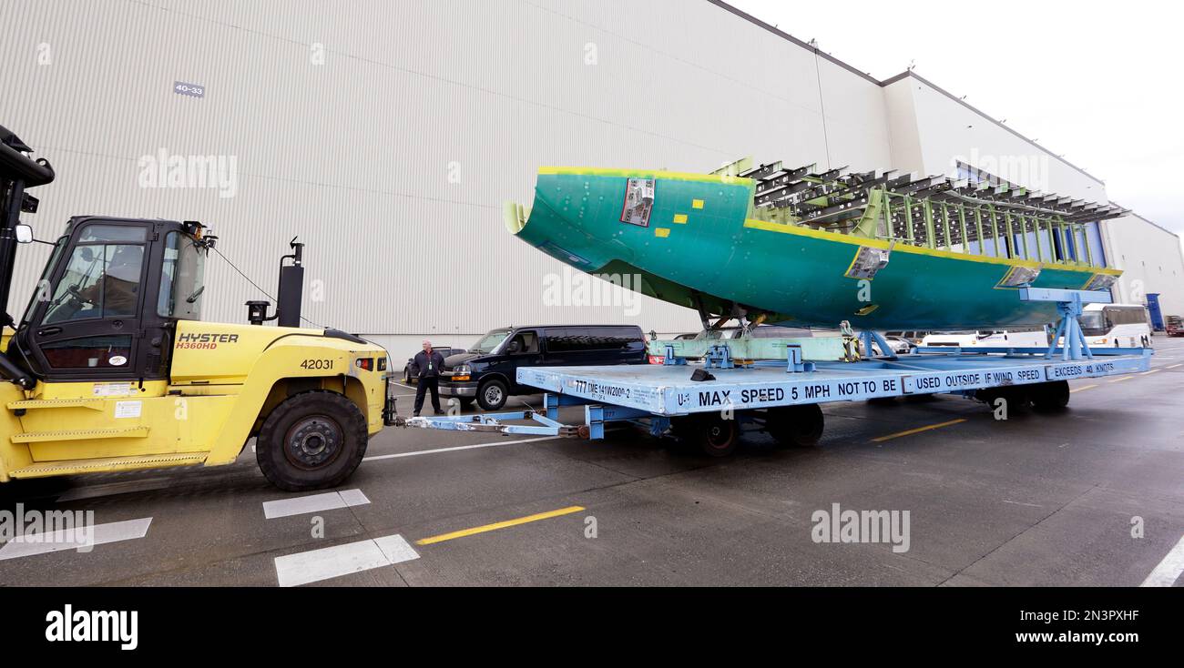 An airplane part is hauled past Boeing's main final assembly building ...