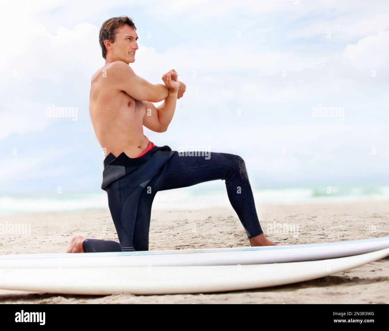 Young surfer stretching on a beach hi-res stock photography and images ...