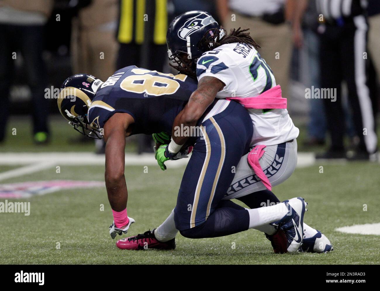 St. Louis Rams wide receiver Kenny Britt, left, is stopped by Seattle ...