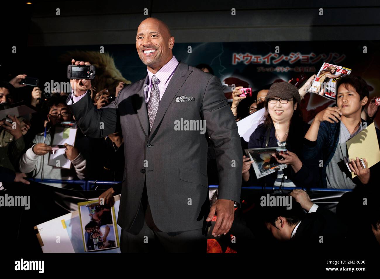 American actor Dwayne Johnson takes photos as he arrives at the red ...