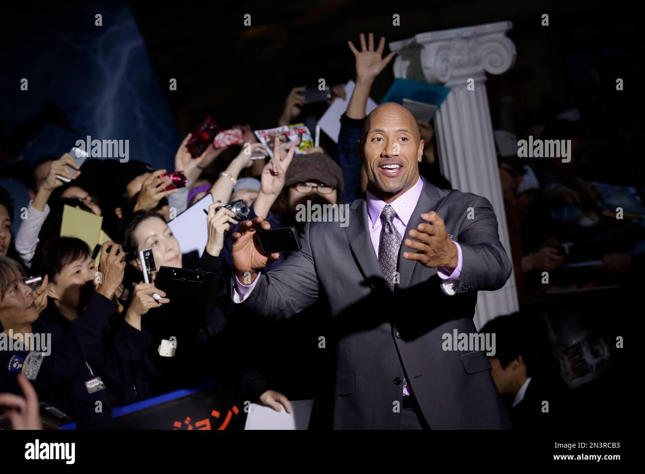 American actor Dwayne Johnson takes photos as he arrives at the red ...