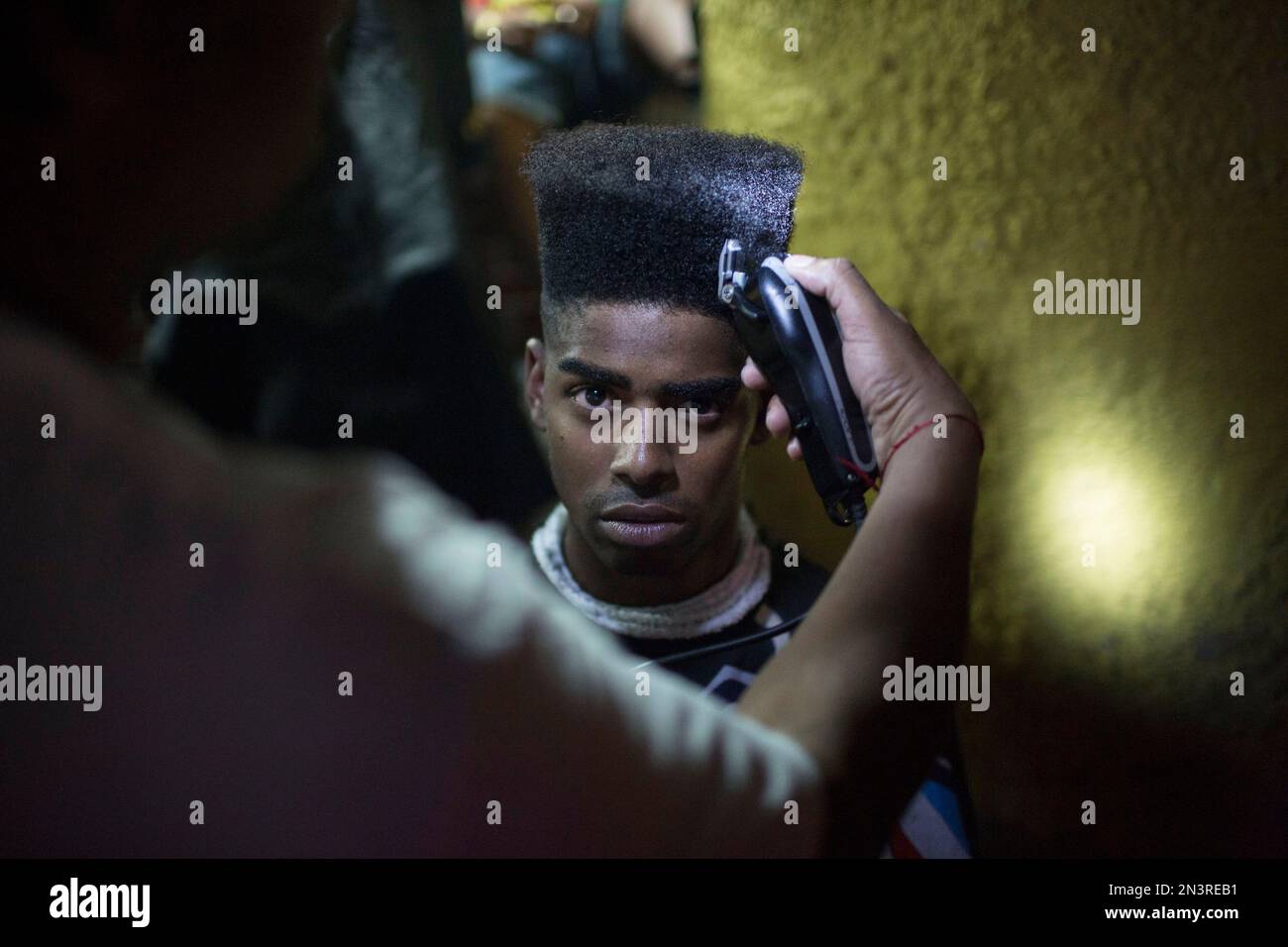 A young man gets his hair cut at a party in Rio de Janeiro, Brazil ...