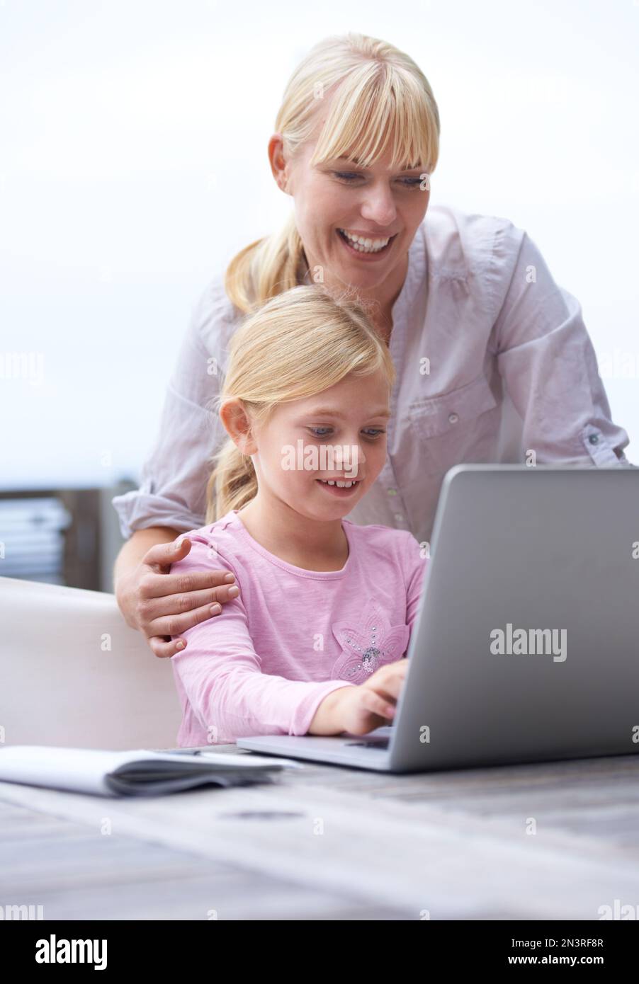Helping her master the digital world. A young mother teaching her ...