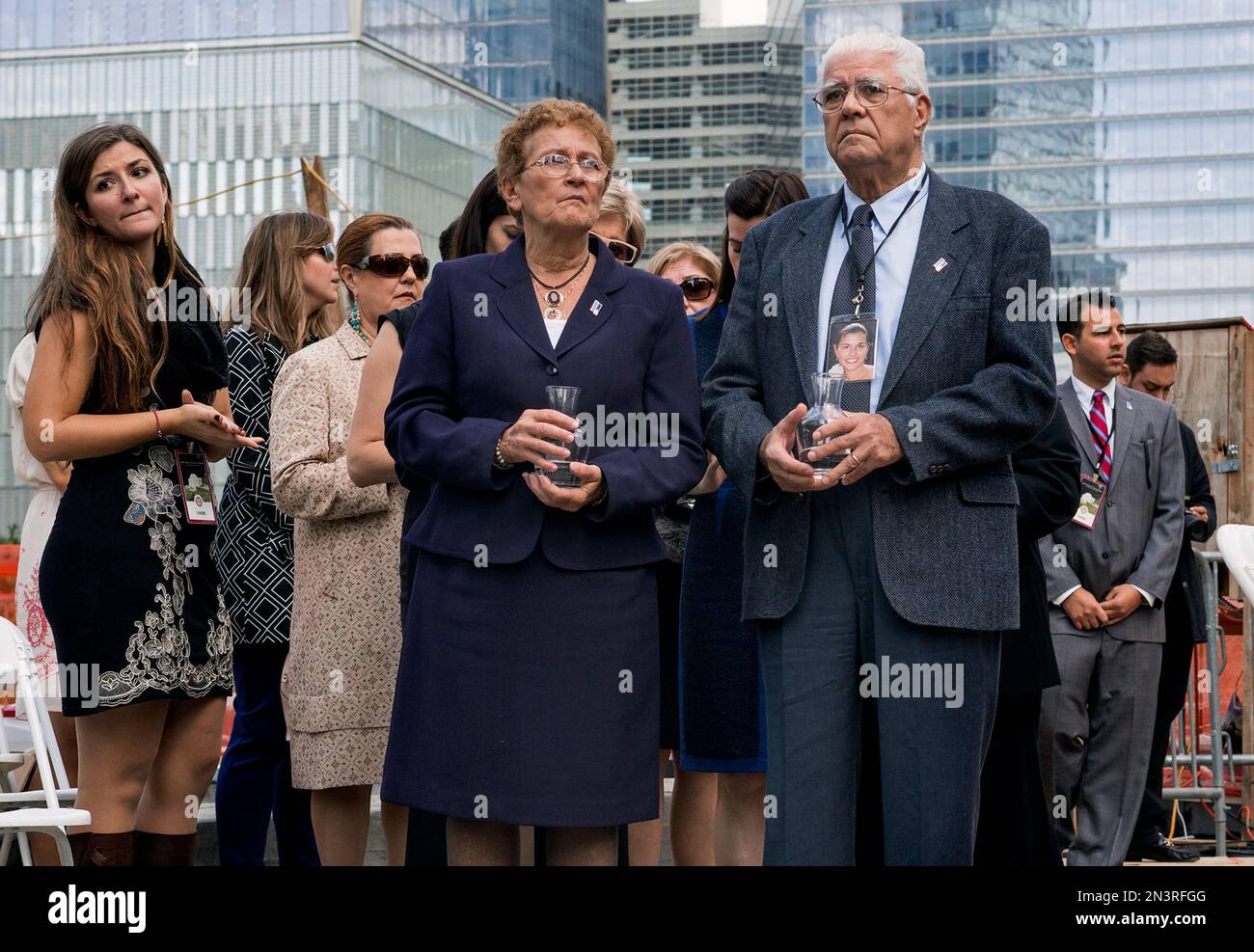 George Kousoulis, foreground right, wearing a lanyard with a picture of ...