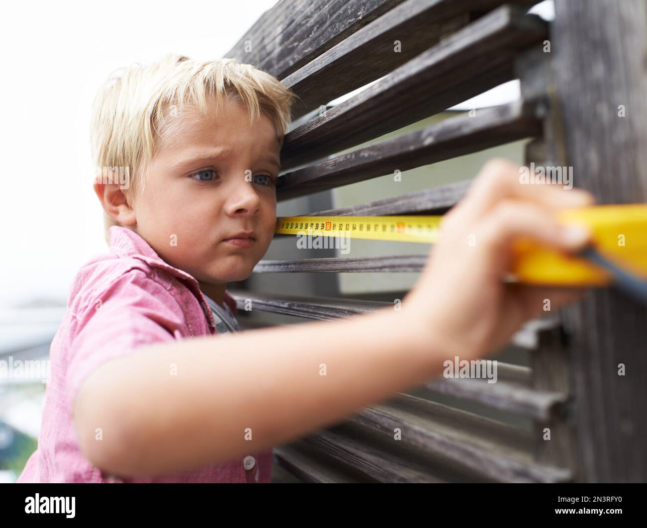 Concentrating on the task dad gave me. a young boy measuring a grill ...