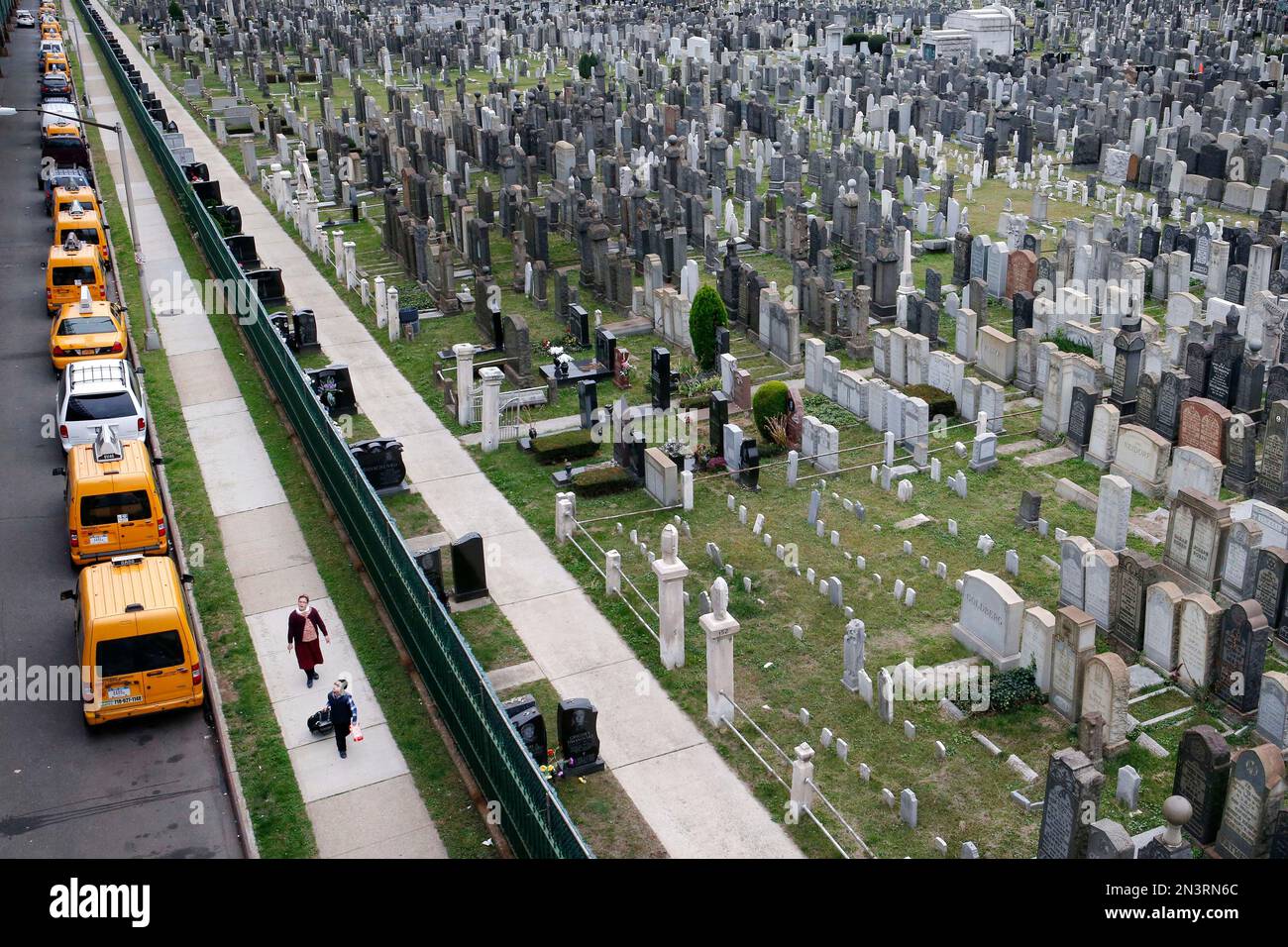 In this Oct. 13, 2014 photo, two people walk past Washington Cemetery ...