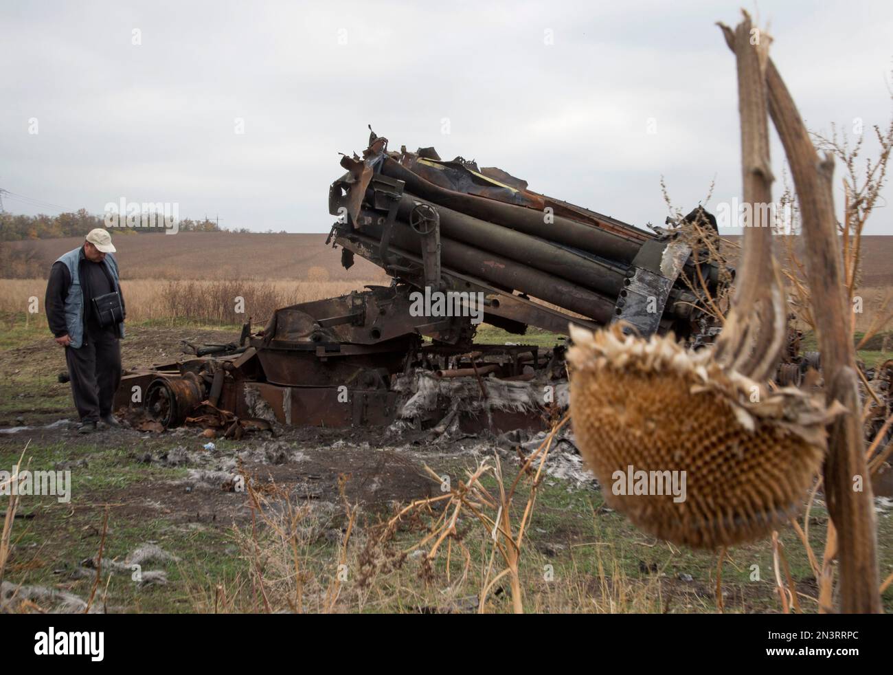A man examines a burned Ukrainian multiple-missile Uragan launcher near ...
