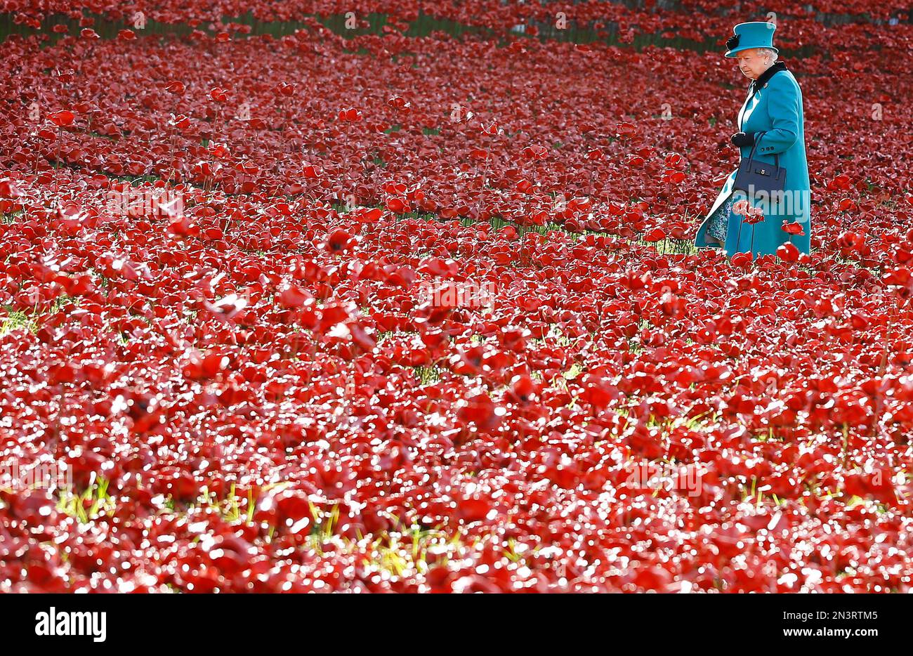 Britain's Queen Elizabeth II walks through a field of ceramic poppies ...