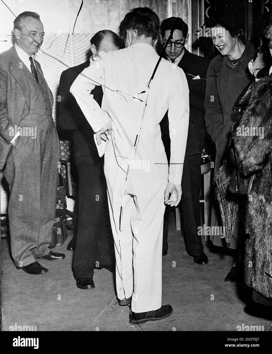 American actress Katharine Hepburn hoists her slacks as she answers ...
