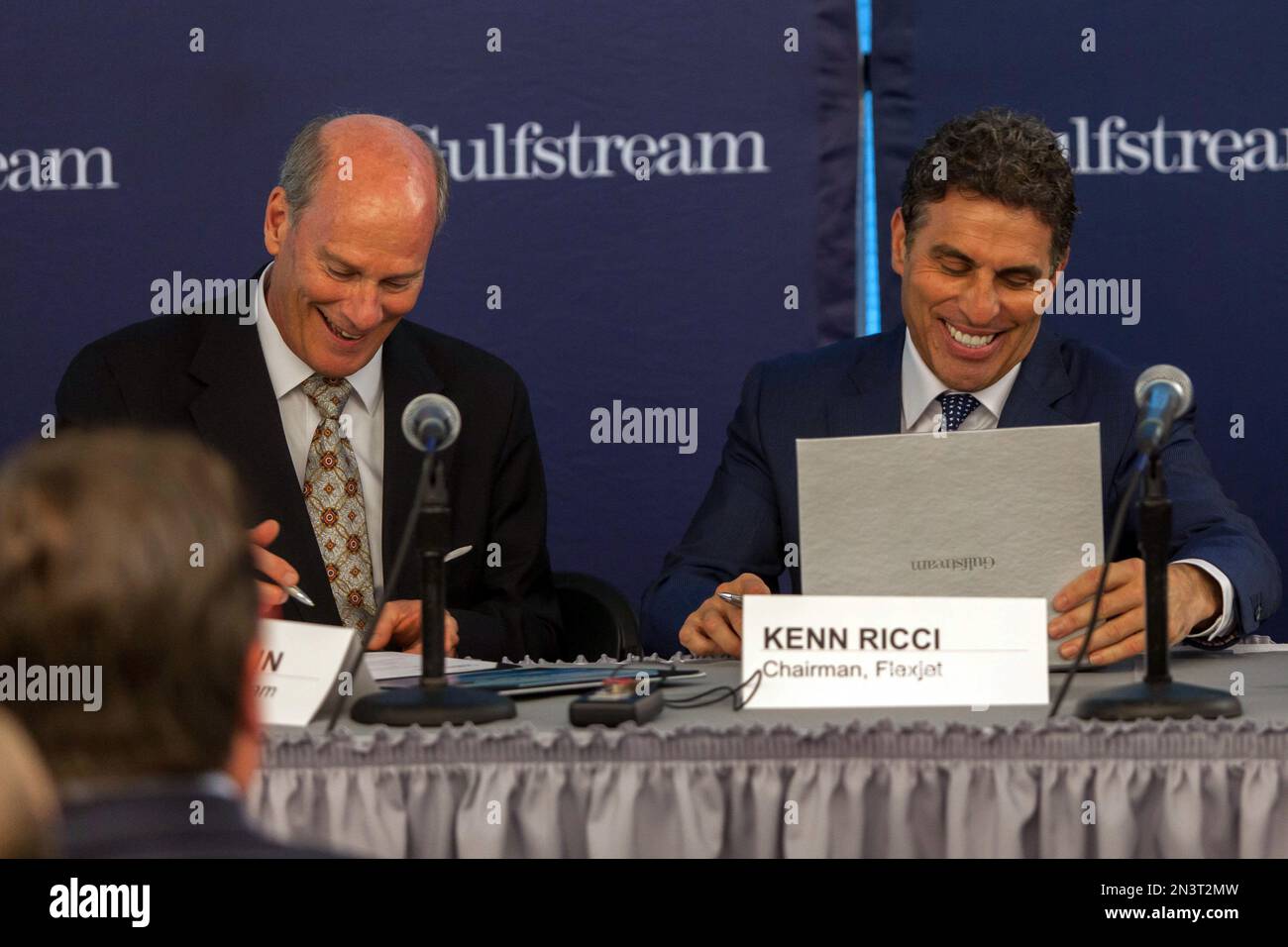 Flexjet Chairman Kenn Ricci signs documents presented to him by ...