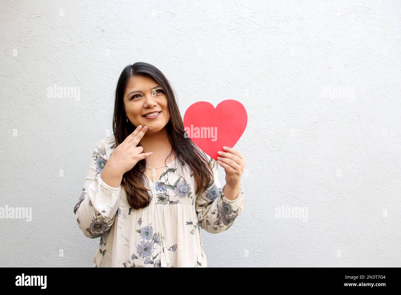 Latin adult woman shows big red heart with enthusiasm for the arrival ...